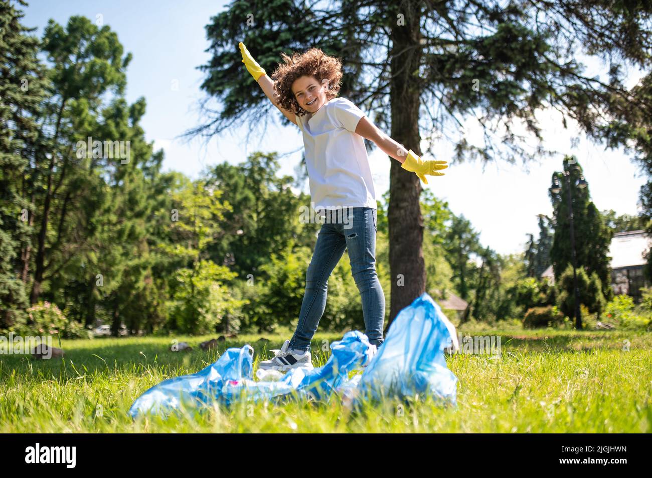 Happy teen jumping having all garbage gathered Stock Photo - Alamy