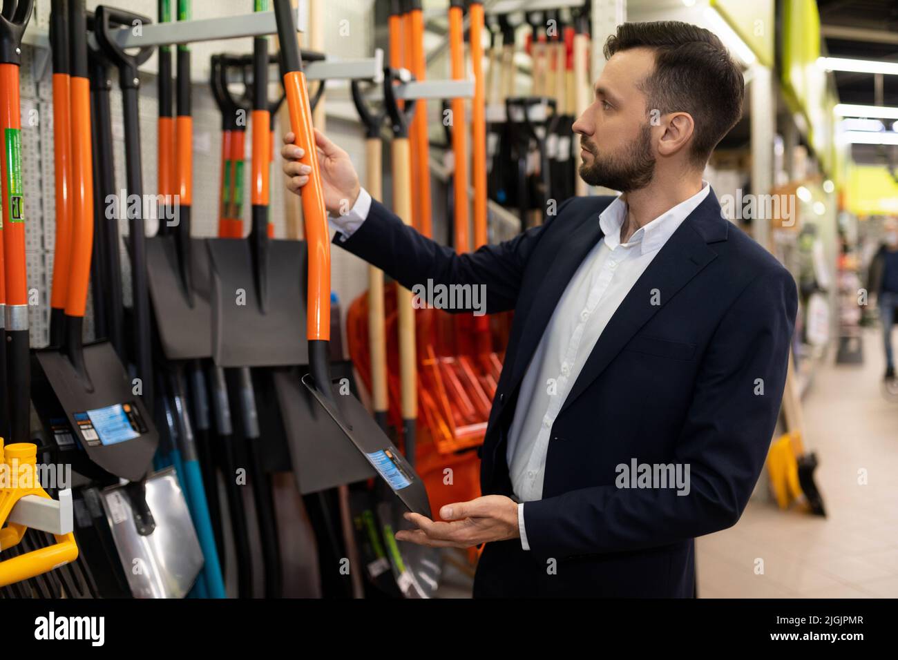 gardening store manager offers a wide range of shovels Stock Photo - Alamy