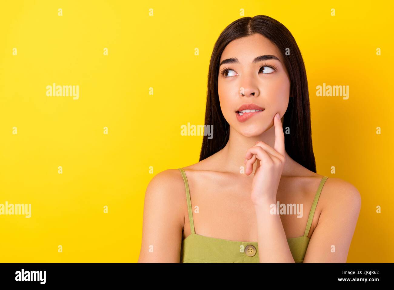 Photo of minded pretty malaysian lady finger touch chin biting lips ...