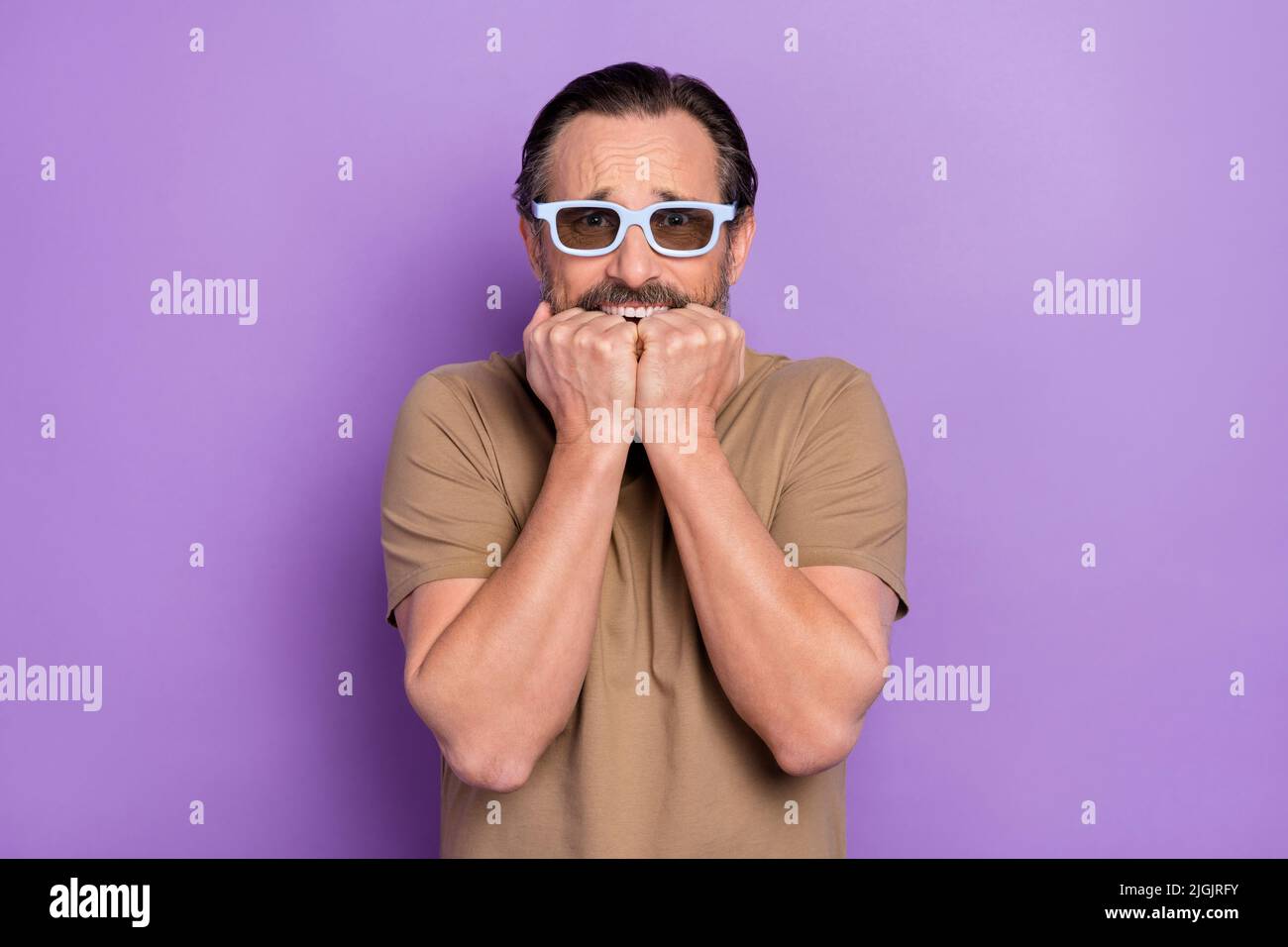 Photo of scared middle-aged man scared to watch 3d horror movie biting ...