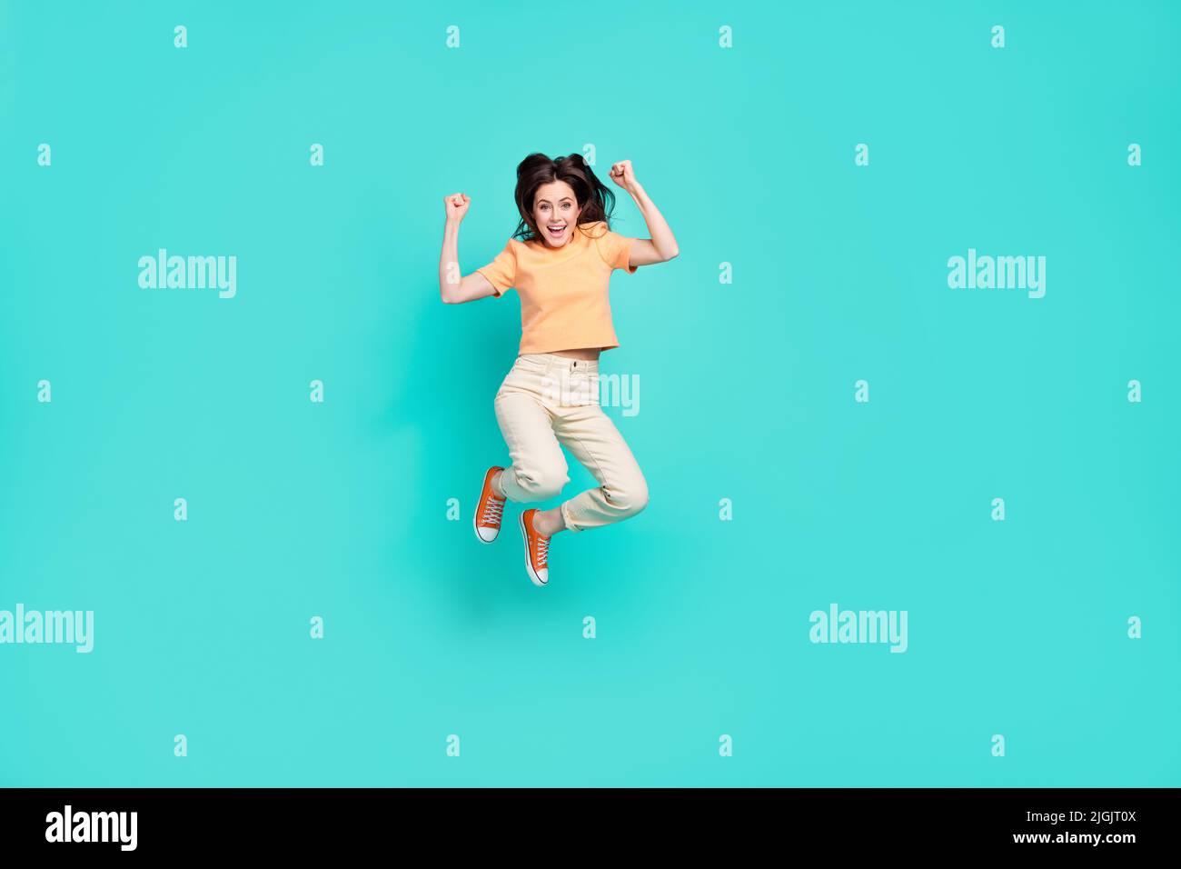 Full size portrait of astonished satisfied lady jump raise fists scream ...