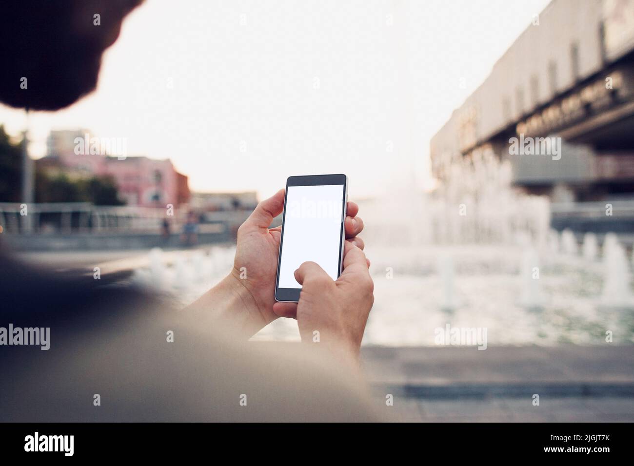 Phone with blank screen in hands over the shoulder Stock Photo - Alamy