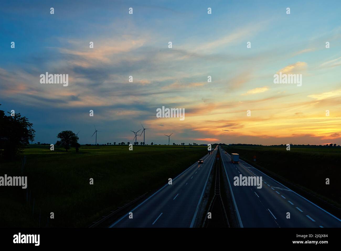 Highway road with car traffic and windmill turbine generator against ...