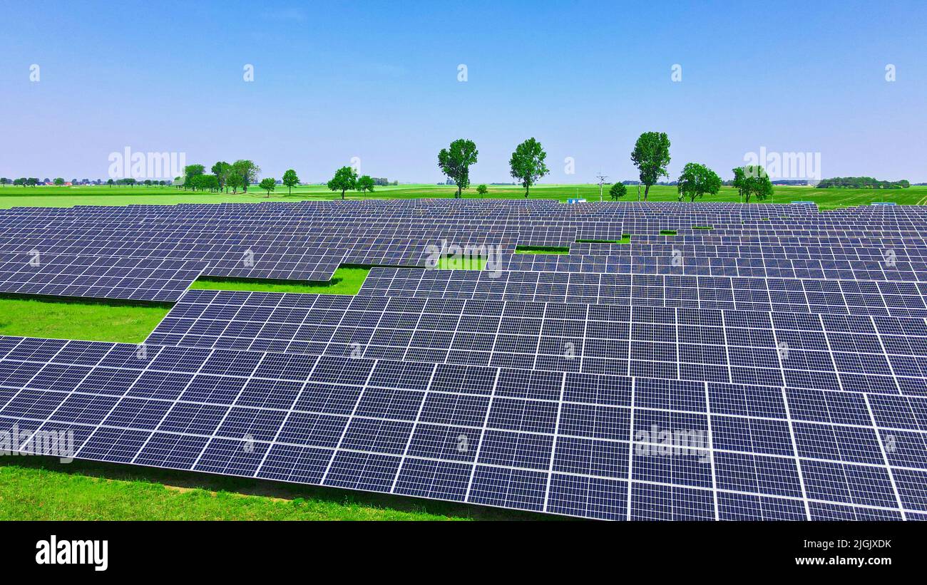 Solar panels battery in green field against blue sky, aerial view ...
