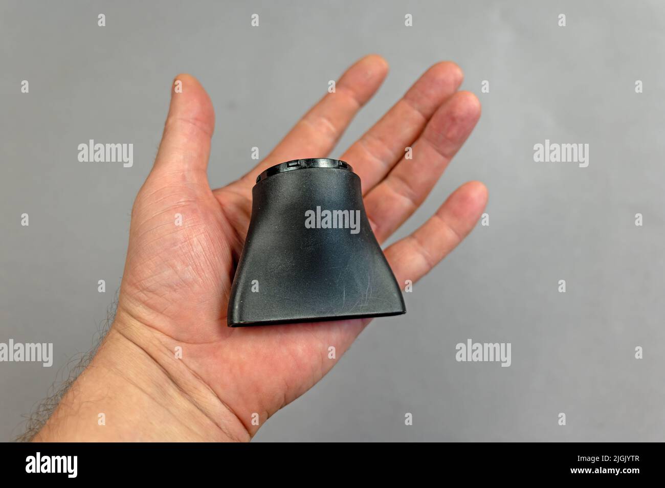 The man is holding the concentrator nozzle for the electric hair dryer ...