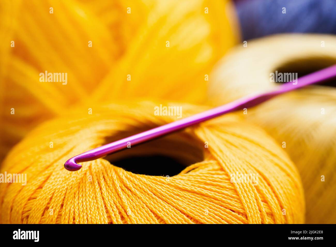 Yellow thread with crochet close-up, background Stock Photo - Alamy
