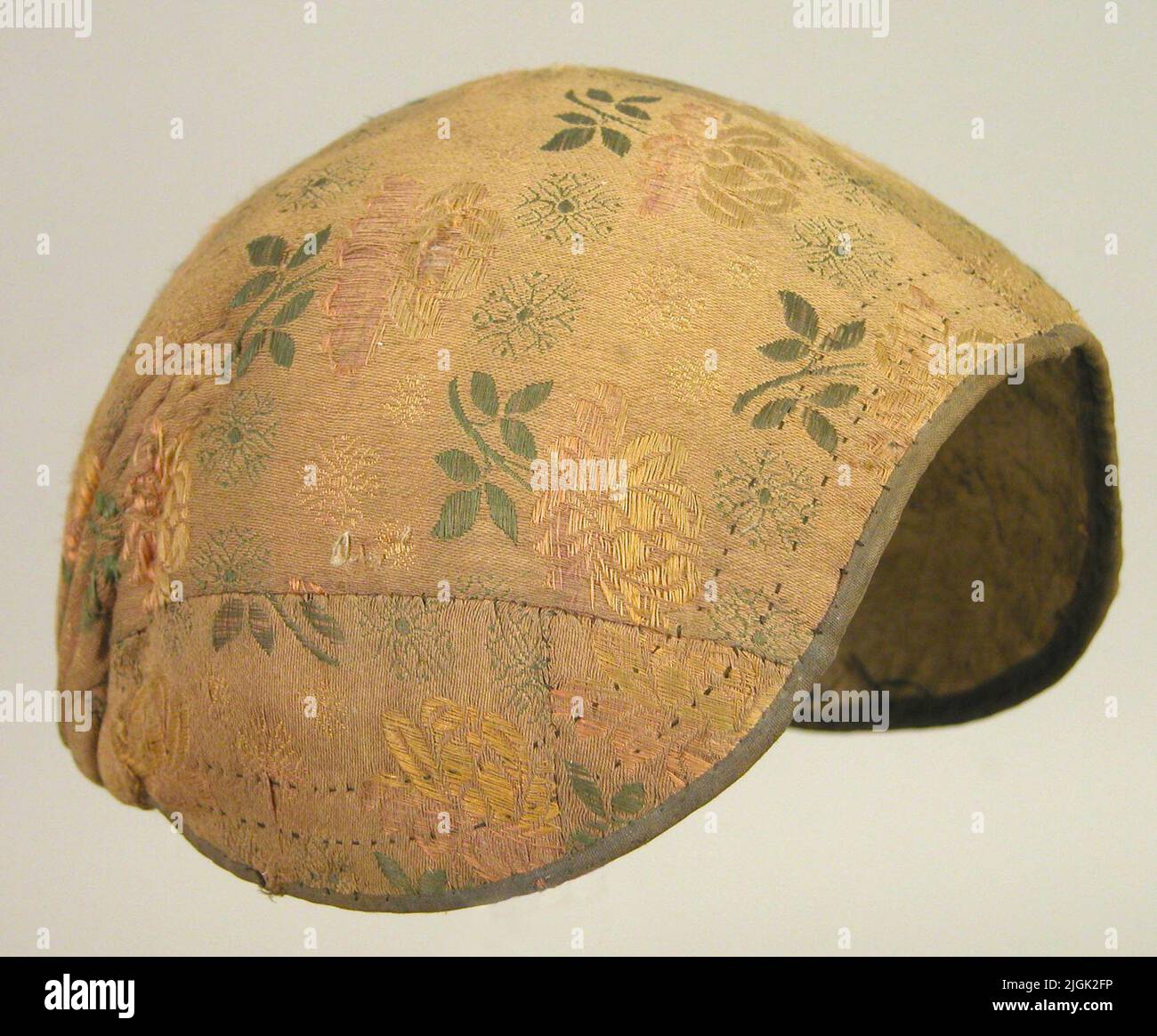 Bindmössa A binding cap of violet floral silk. 4 folded folds on each ...