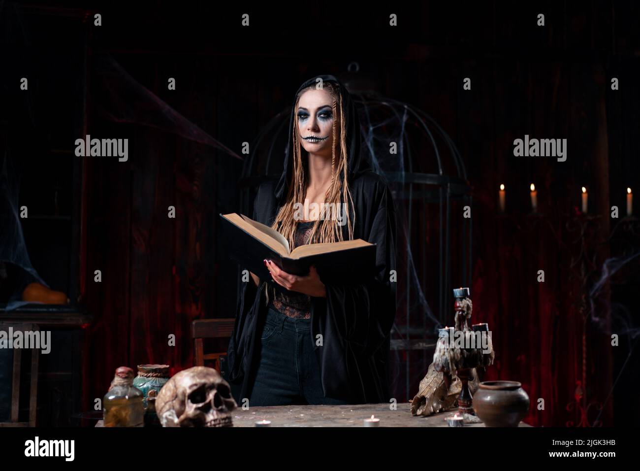 Halloween concept. Witch dressed black hood with dreadlocks standing ...