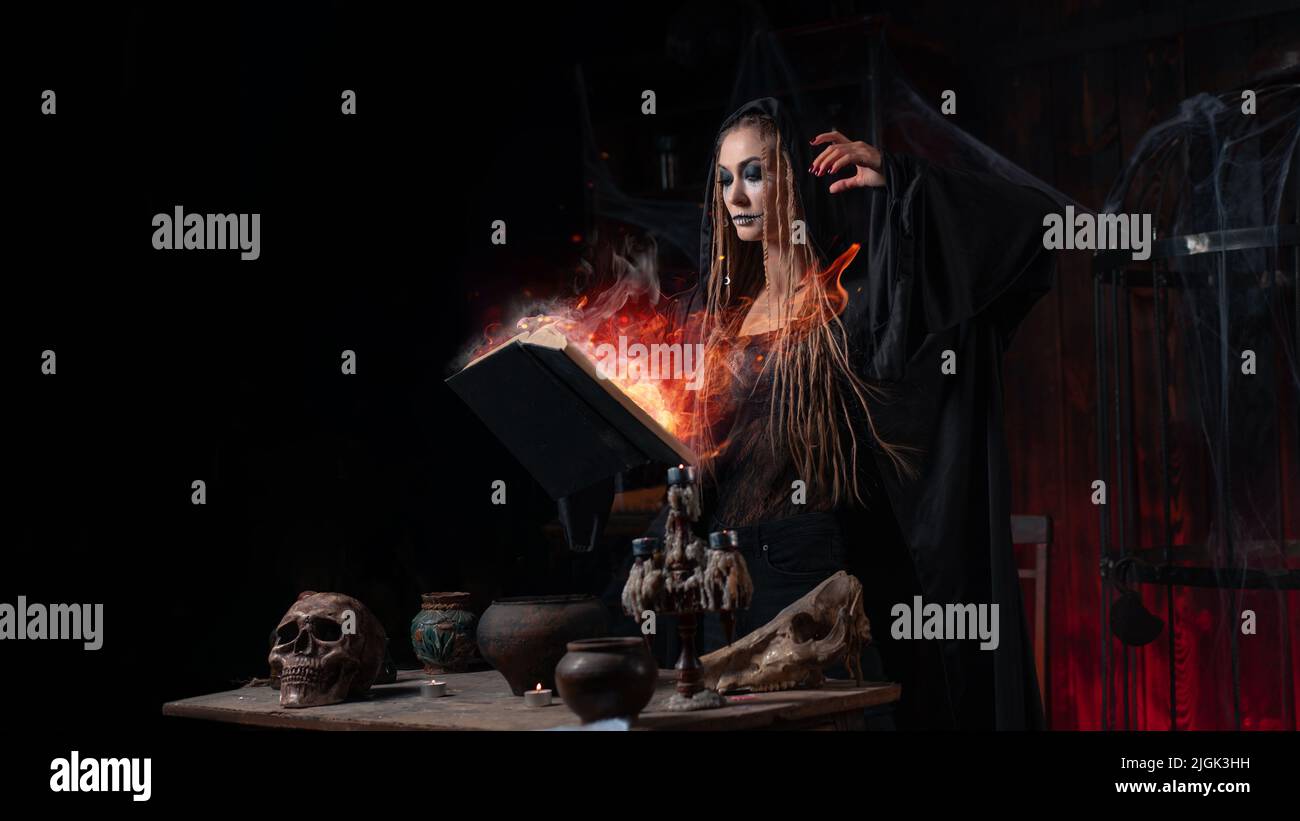 Halloween concept. Witch dressed black hood standing dark dungeon room ...