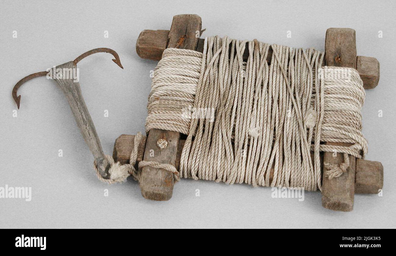 Pilk Jig. Silver colored lead. Two embedded hooks. At one end a hole ...