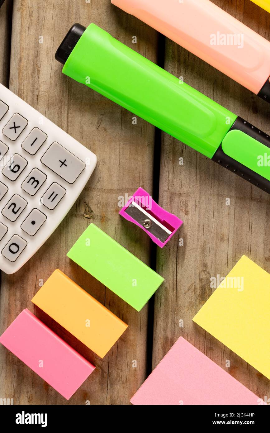 Vertical composition of colorful post it cards and calculator on wooden ...