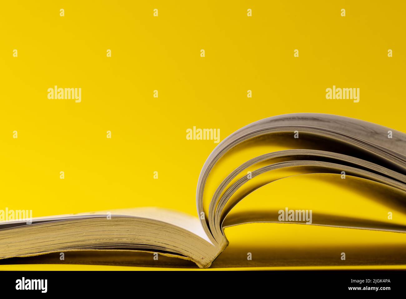Image of open book on yellow surface with copy space Stock Photo - Alamy
