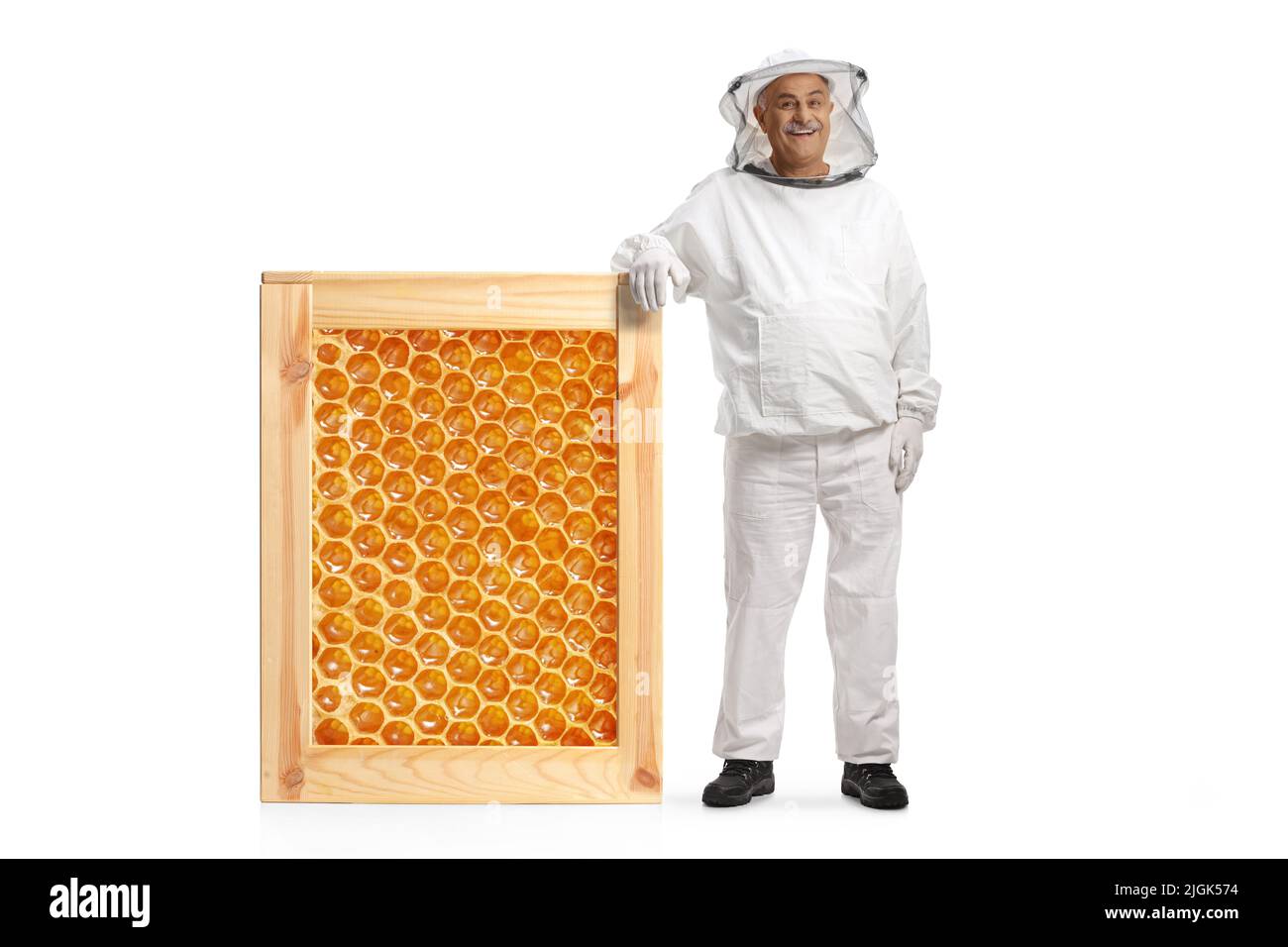 Mature male bee keeper in a uniform leaning on a honeycomb frame ...