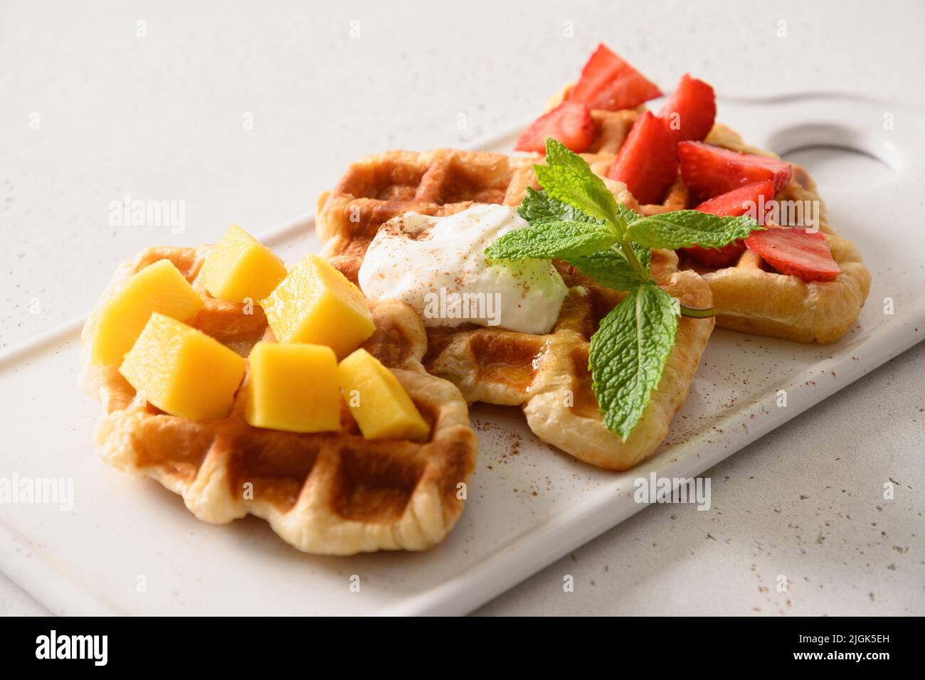 Crispy croffles with different fruits topping of strawberries, mango on ...