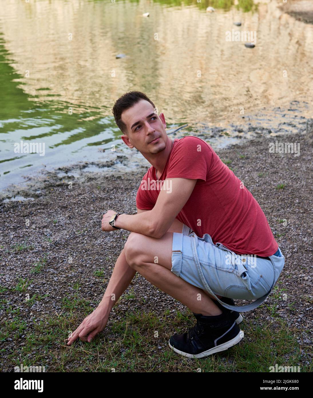 High angle view portrait of young man crouching hi-res stock ...