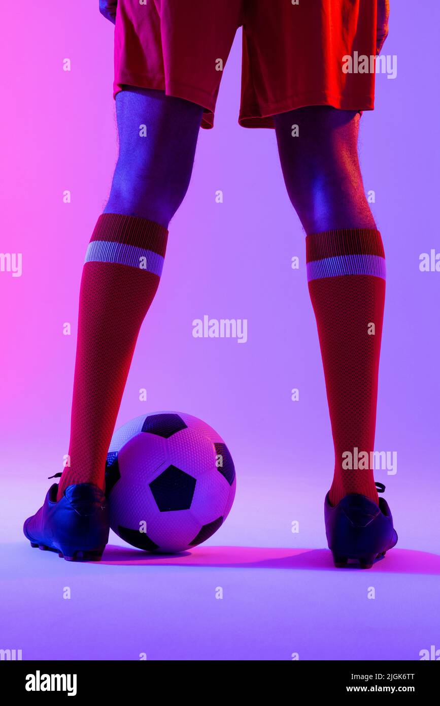 African american male soccer player with football over neon pink ...