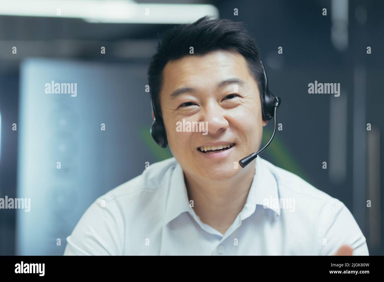 Close-up photo portrait of Asian man with video call headset, tech ...