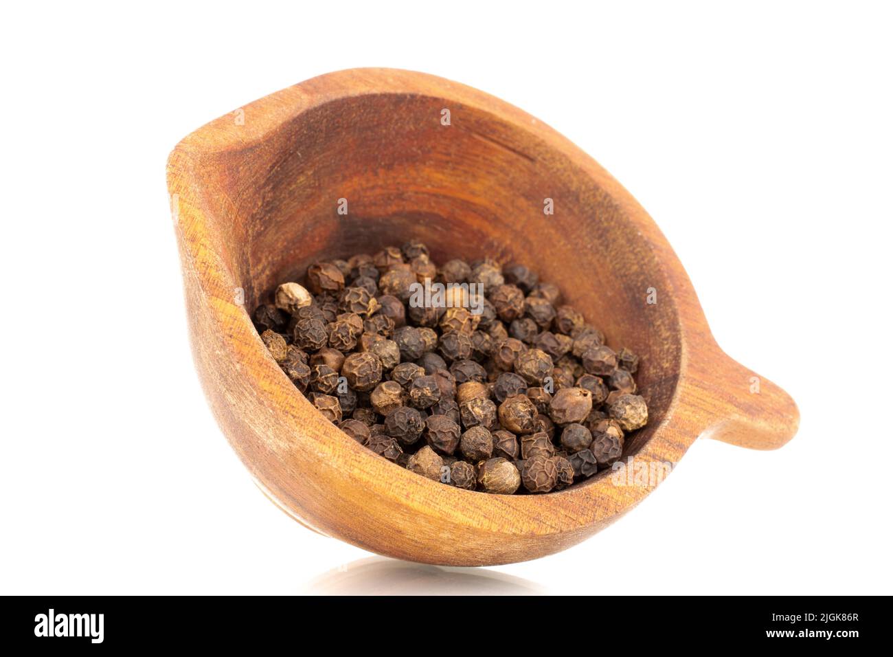Dry fragrant black pepper in a wooden cup, close-up, isolated on a ...