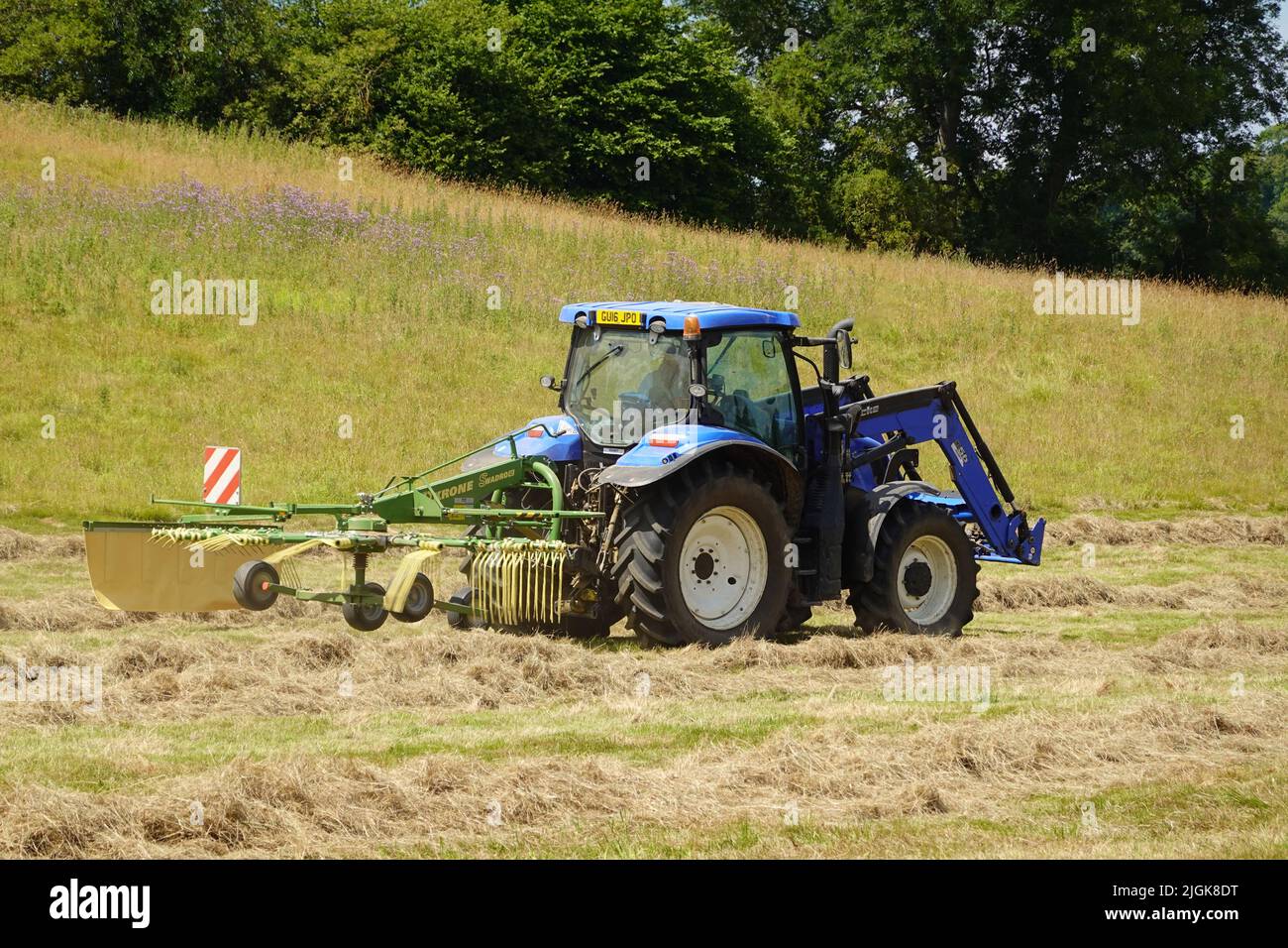 Farmer preparing straw for bailing near Hartfield East Sussex, England ...