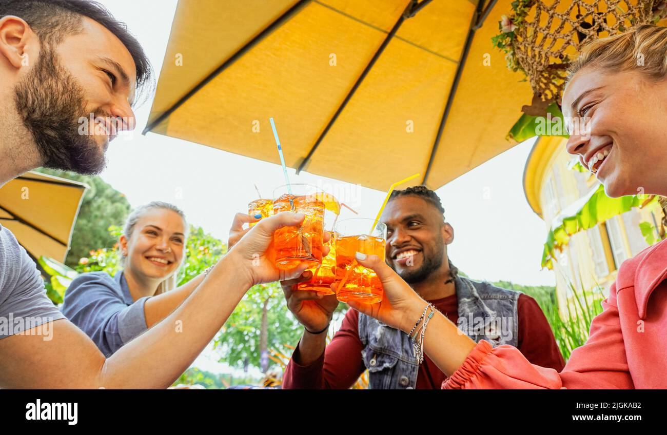 Group of young people having fun outside in a bar with drinks in summer ...