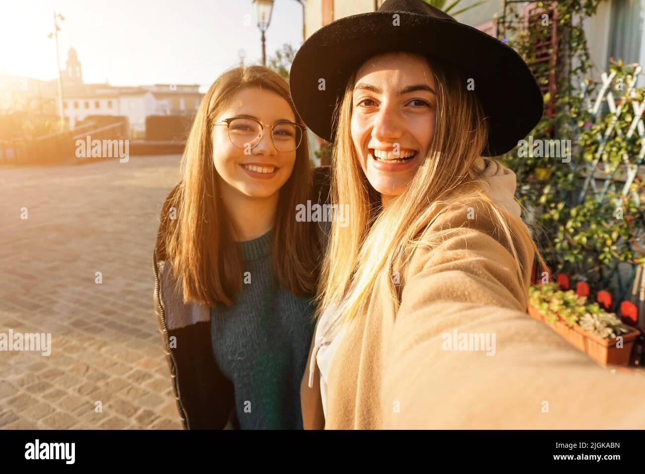 Teenagers taking selfie in sunset - Girls smiling at the camera and ...