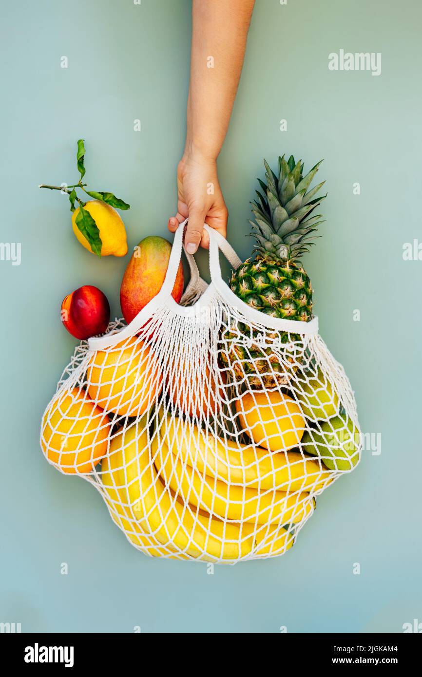 Top view female hand holding string bag, mesh bag, grocery bag with ...