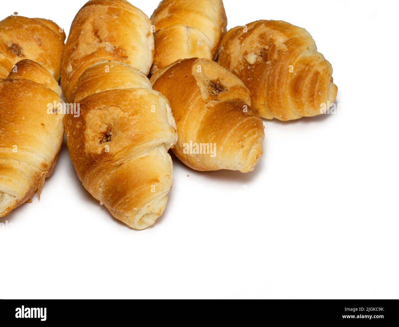 Many small croissants on a white background. Croissants with boiled ...