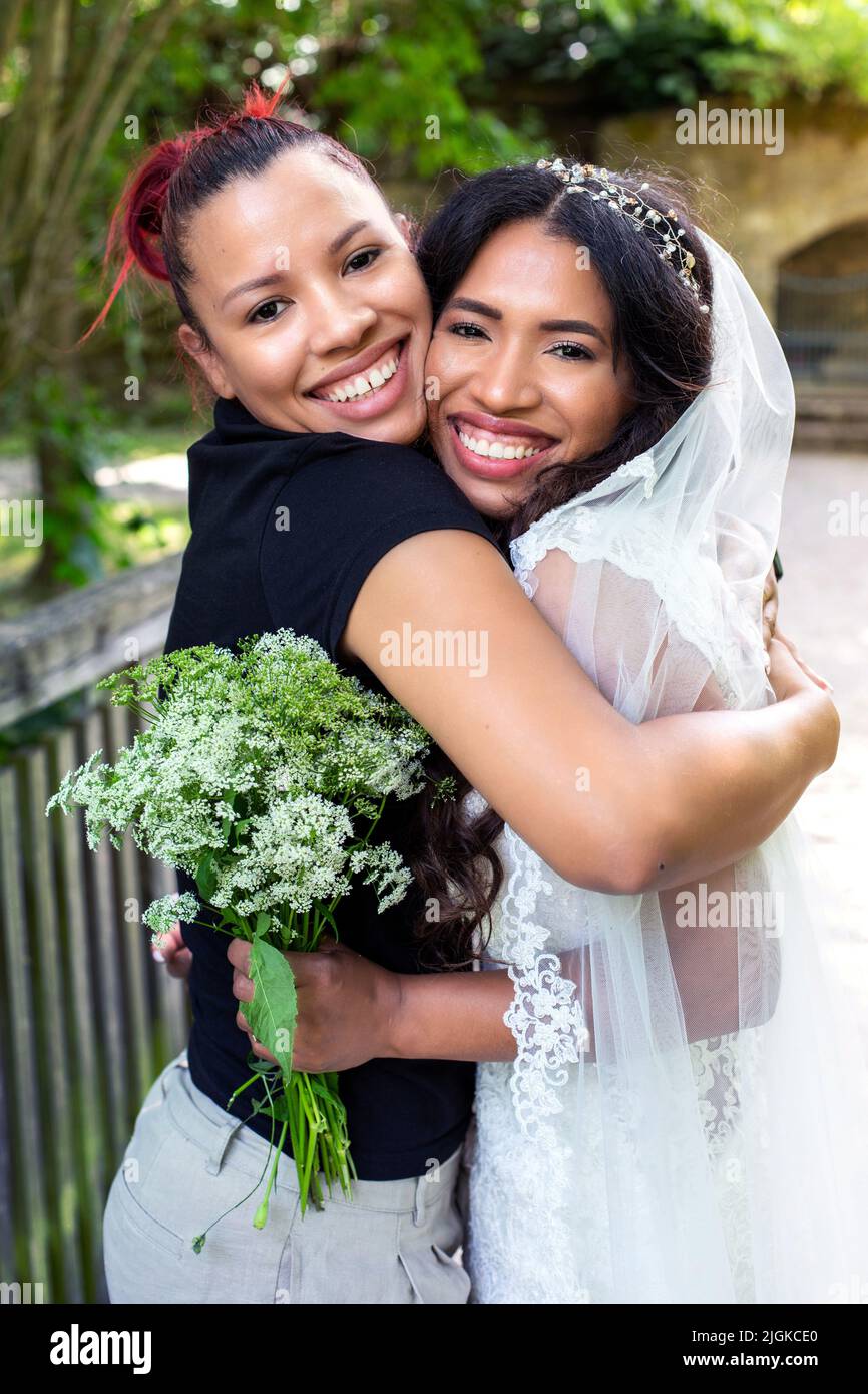 portrait of beautiful african-american bride hugging her best friend ...