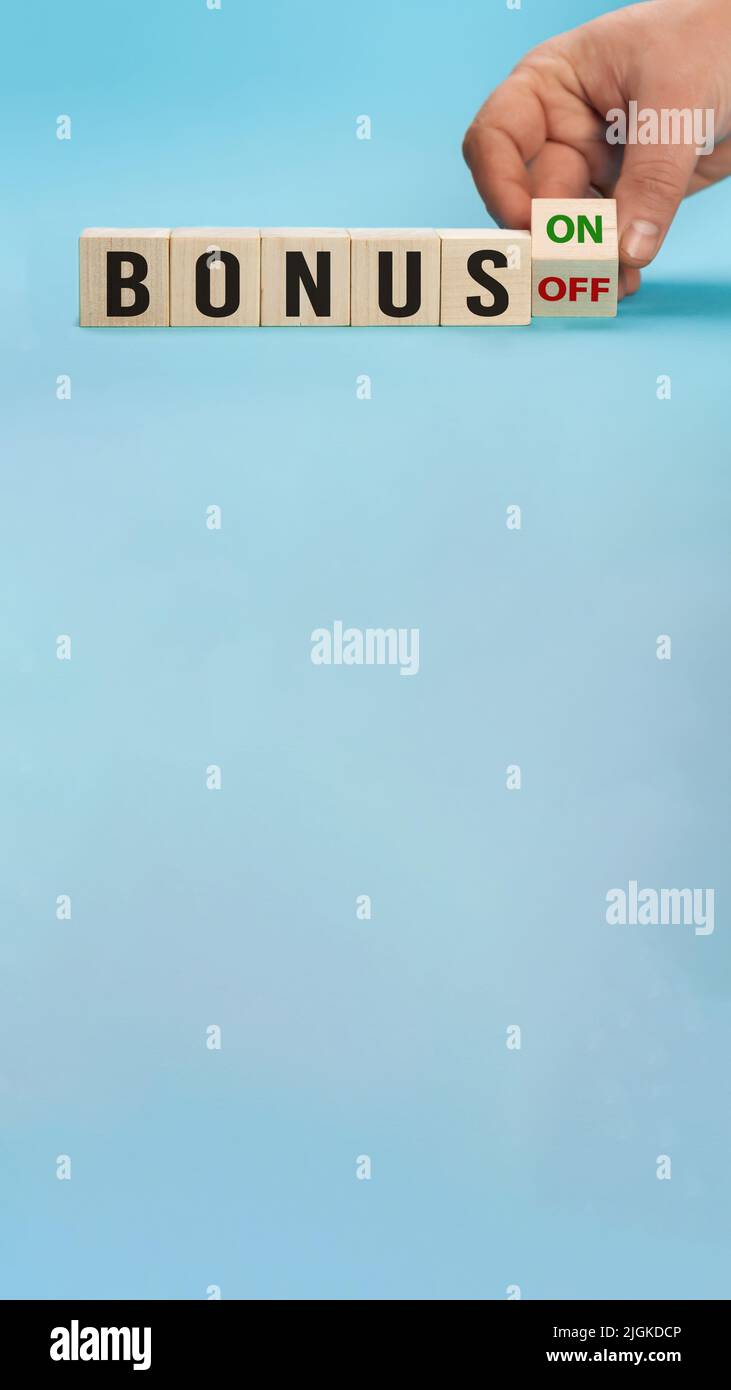 Bonus is going up or vice down. Hand is turning wooden cubes a dice and ...