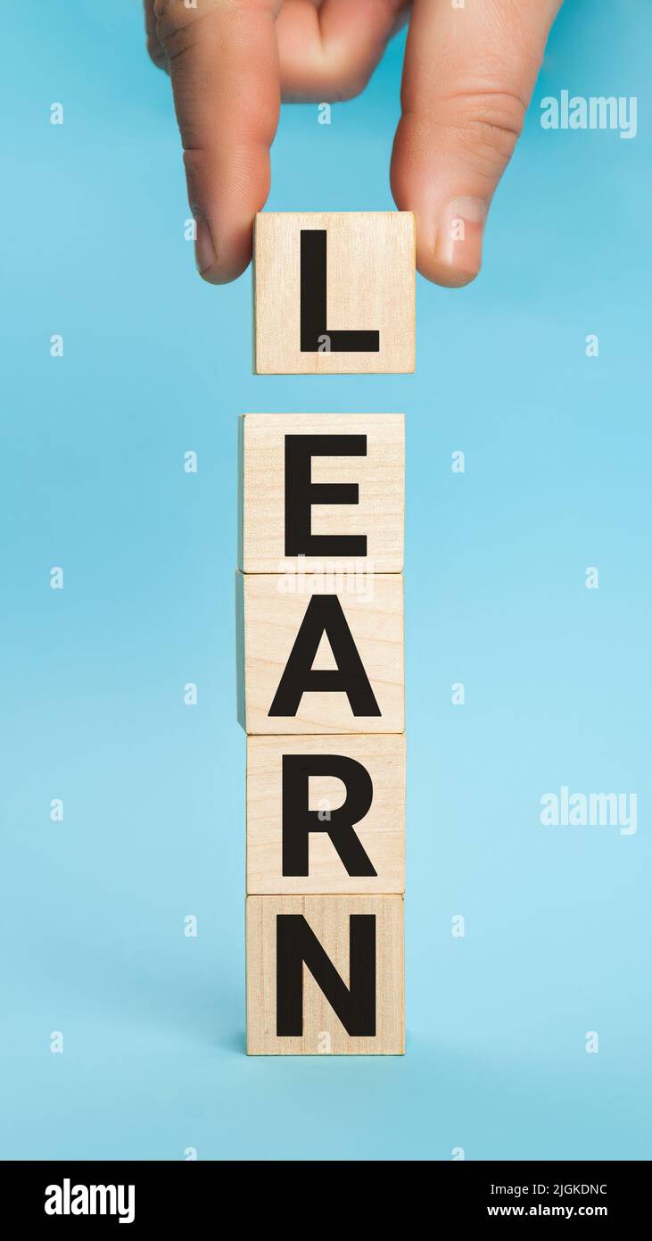 Learn or earn Hand lifts a dice and changes the word learn to earn ...