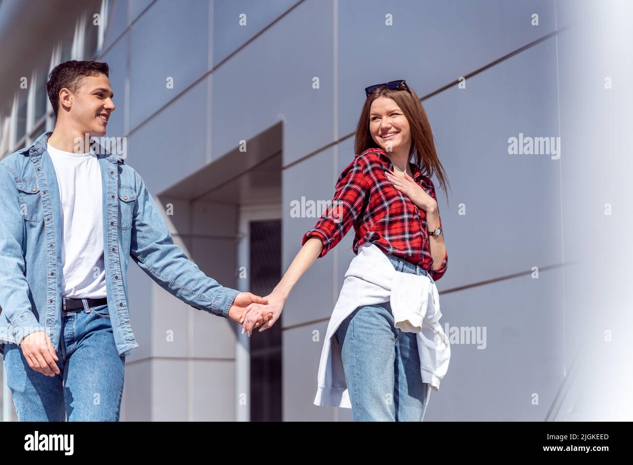 Pretty couple smiling at eachother while walking Stock Photo - Alamy