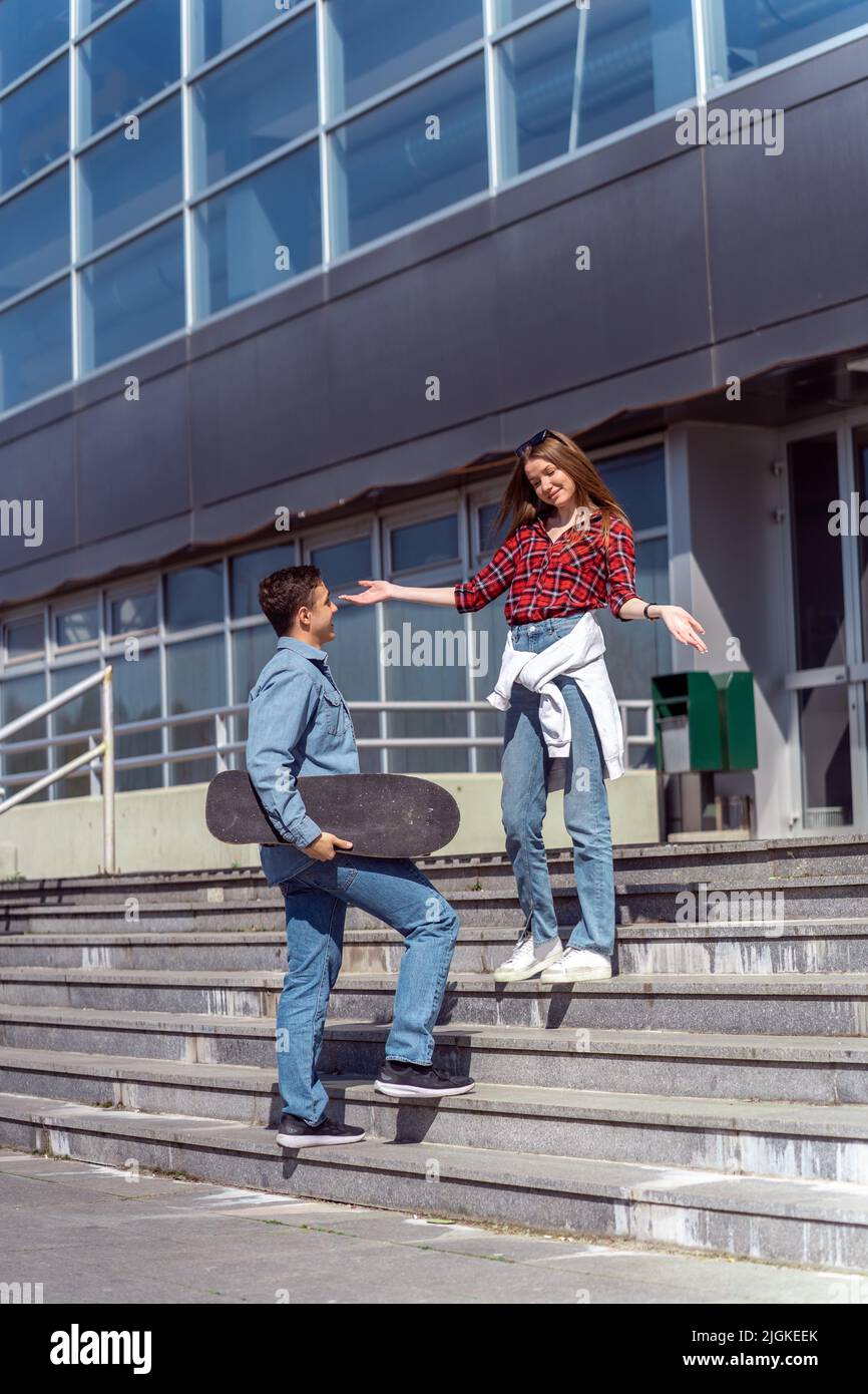 Cute couple talking while standing on the stairs in front of the ...