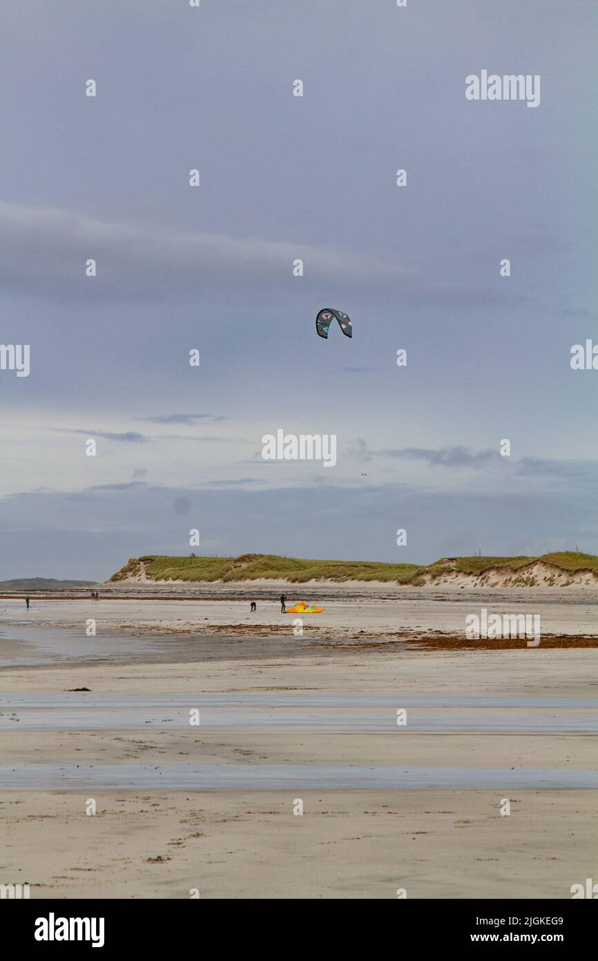 Kite Surfers on the tidal island of Baile Sear, North Uist, Hebrides ...