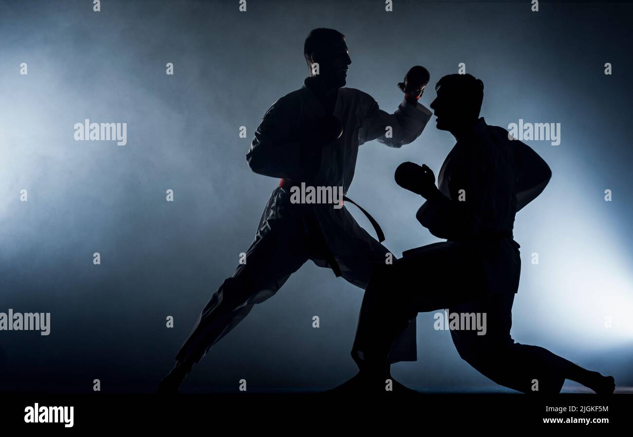 Strong fit athlete, karate men or fighters in white kimono, suit, with ...