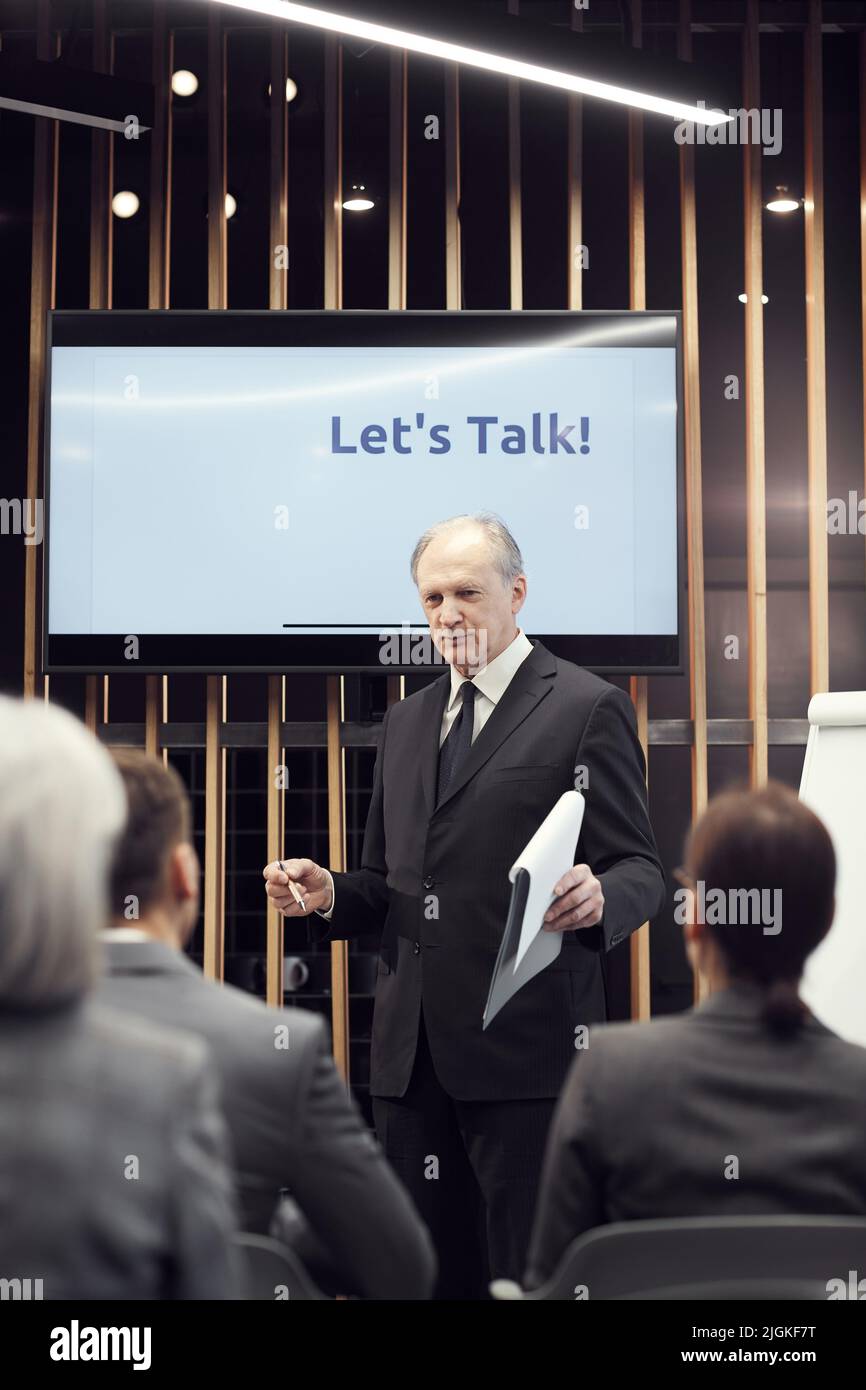 Content balding senior executive in formal suit holding clipboard and ...
