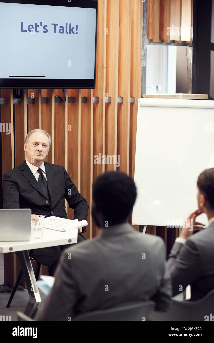 Content pensive senior business speaker with gray hair sitting in ...
