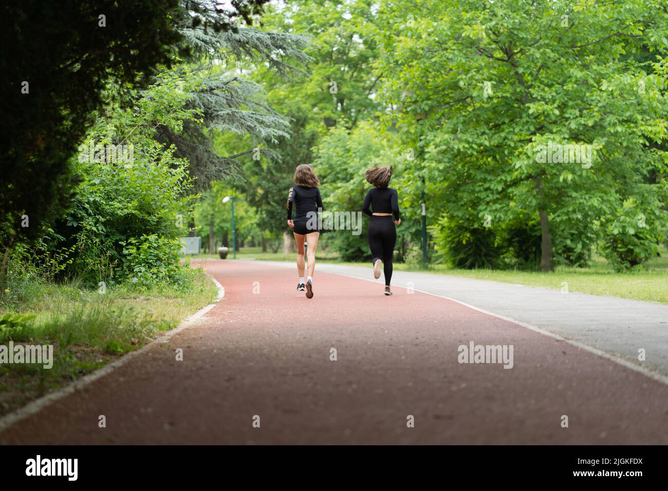 Beautiful and attractive young girls are running on the running track ...