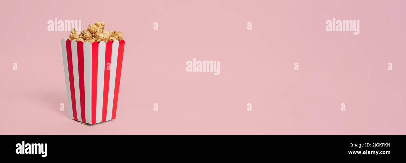 Movie Popcorn in striped bucket isolated on pink pastel background with ...