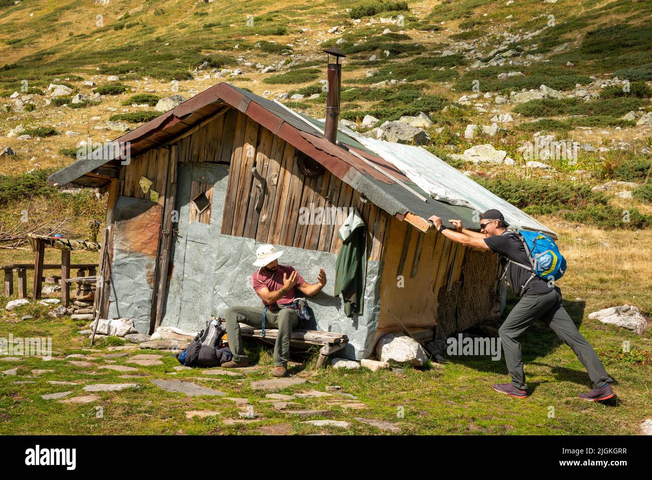 Hikers having fun at an unstable tilted wooden hut Rila Mountain ...