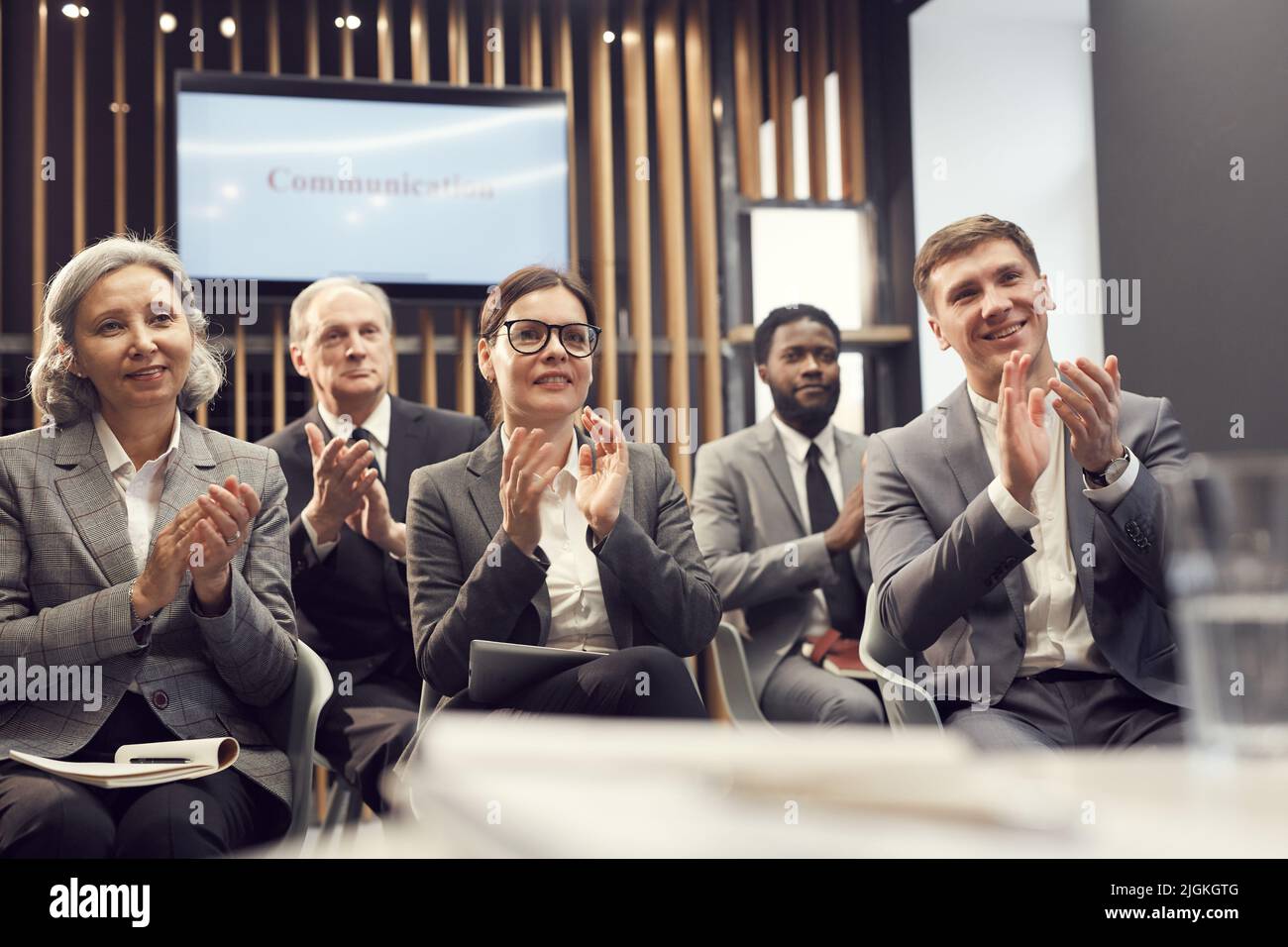 Group of cheerful multi-ethnic business conference participants sitting ...