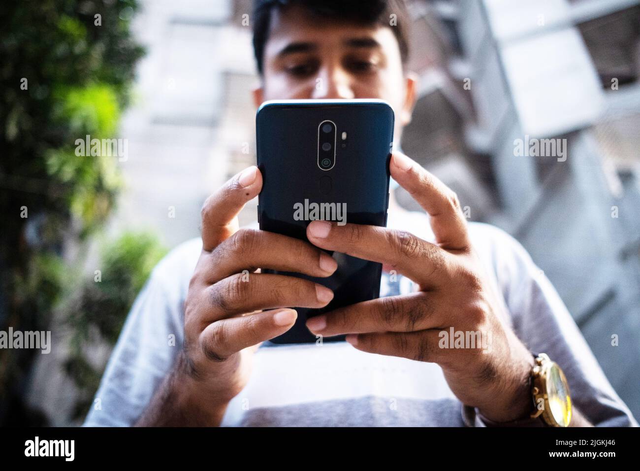 A boy looking at his phone. Dhaka, Bangladesh Stock Photo - Alamy