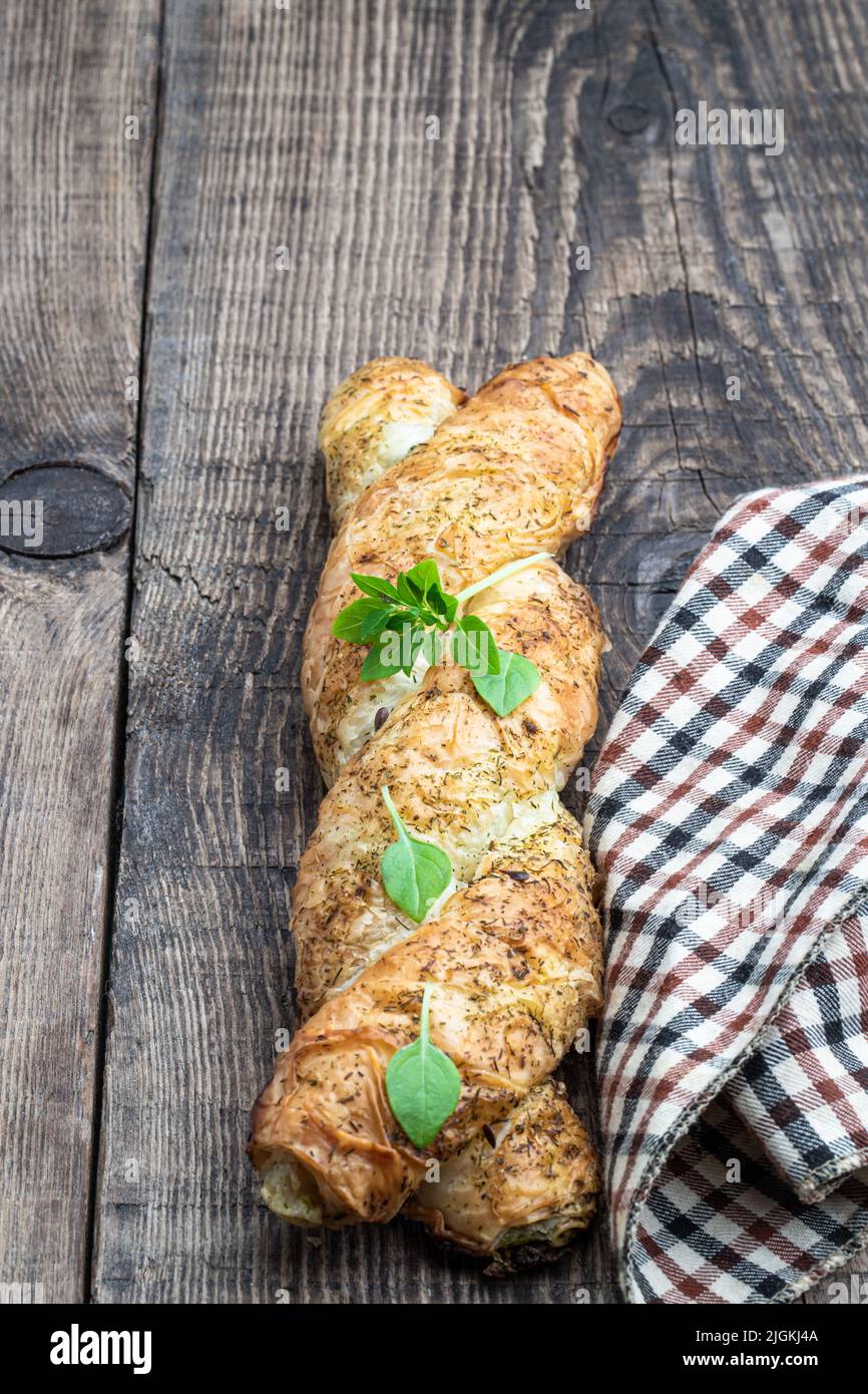 Puff pastry braid stuffed with minced meat on wooden table Stock Photo ...