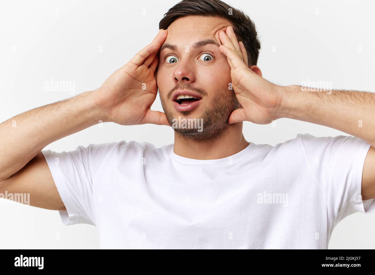 Shocked excited confused tanned handsome man in basic t-shirt touch ...