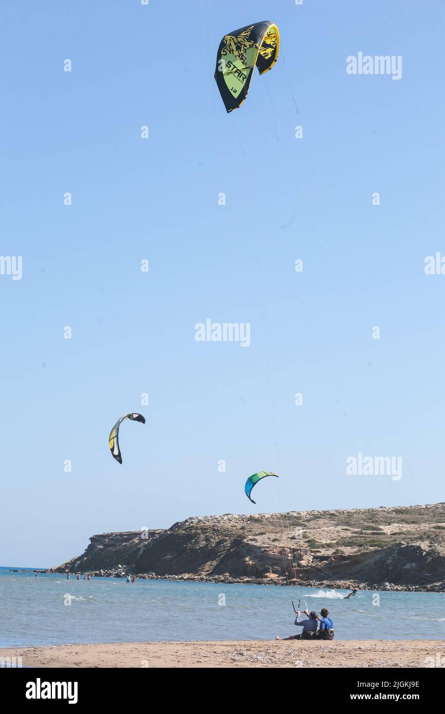Professional kite surfer rides on a board with a plank on a lake with ...