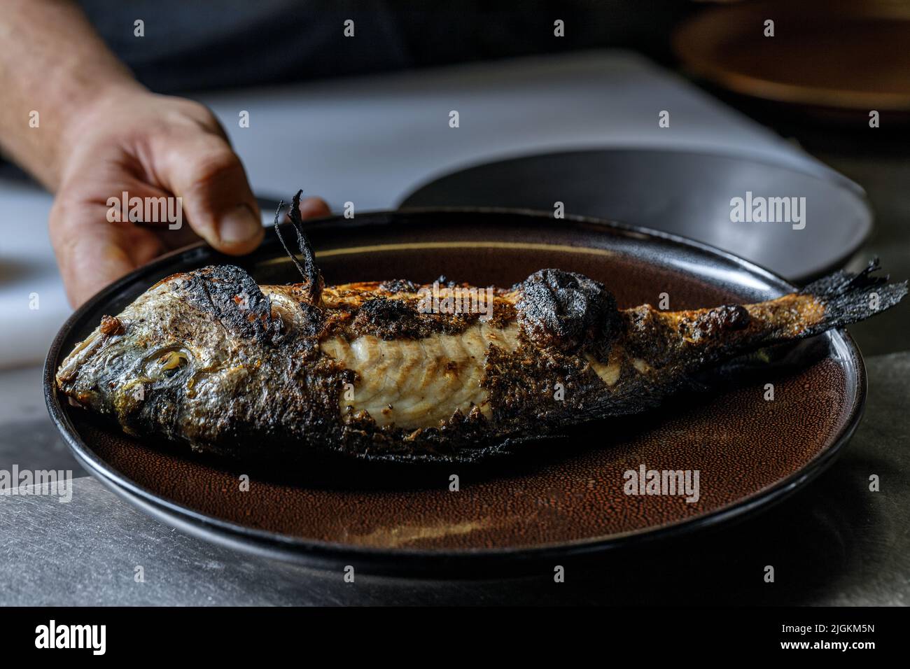 process of grilling whole Sea Bream fish on a barbecue grill over hot ...