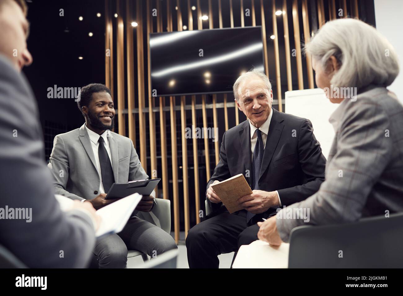 Contented Multi Ethnic Business People In Formalwear Sitting In Circle