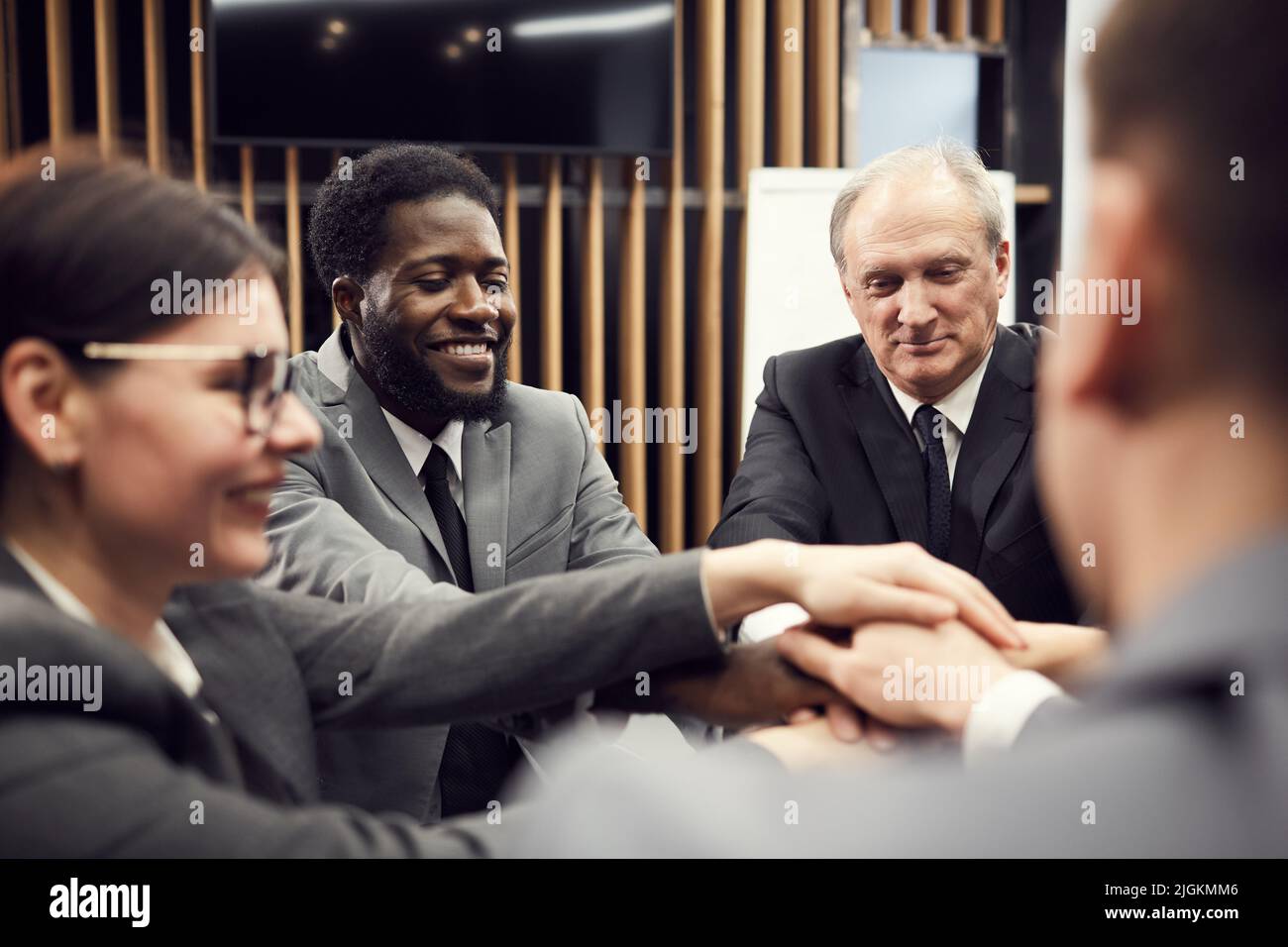 Group of positive excited multi-ethnic business colleagues standing in ...