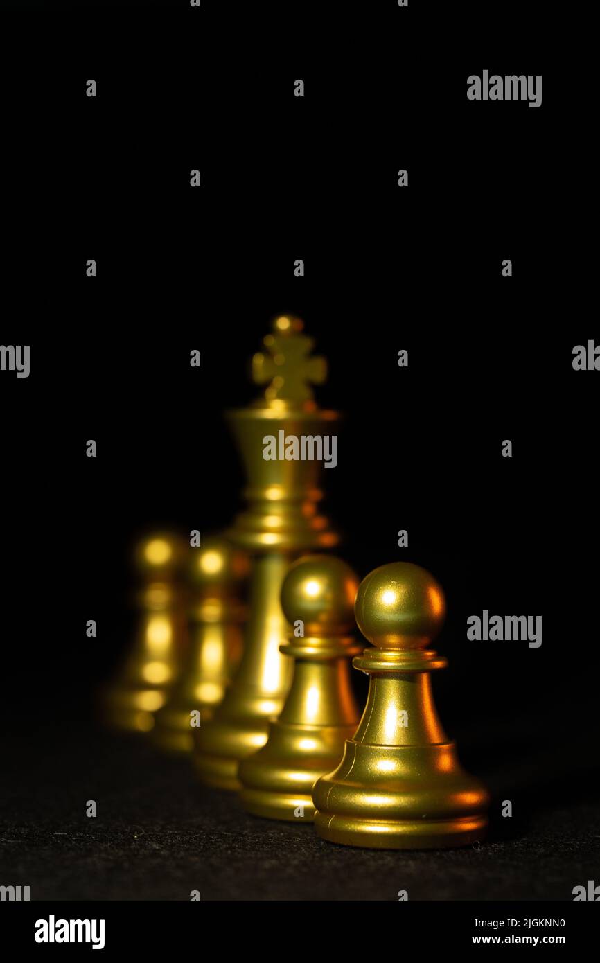chess pieces in gold on a black background Stock Photo - Alamy
