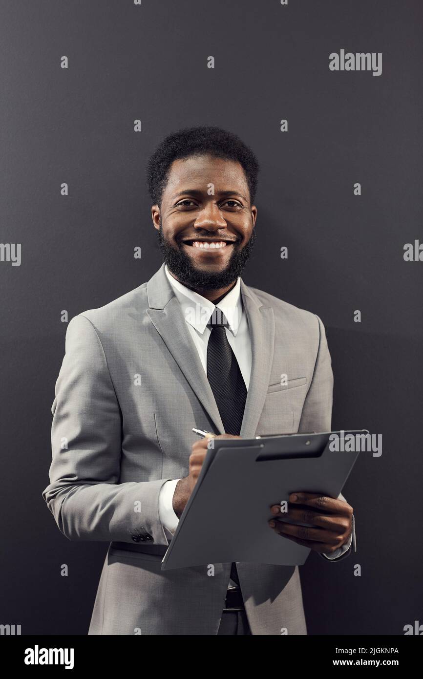 Portrait of smiling handsome black manager with bushy beard standing ...