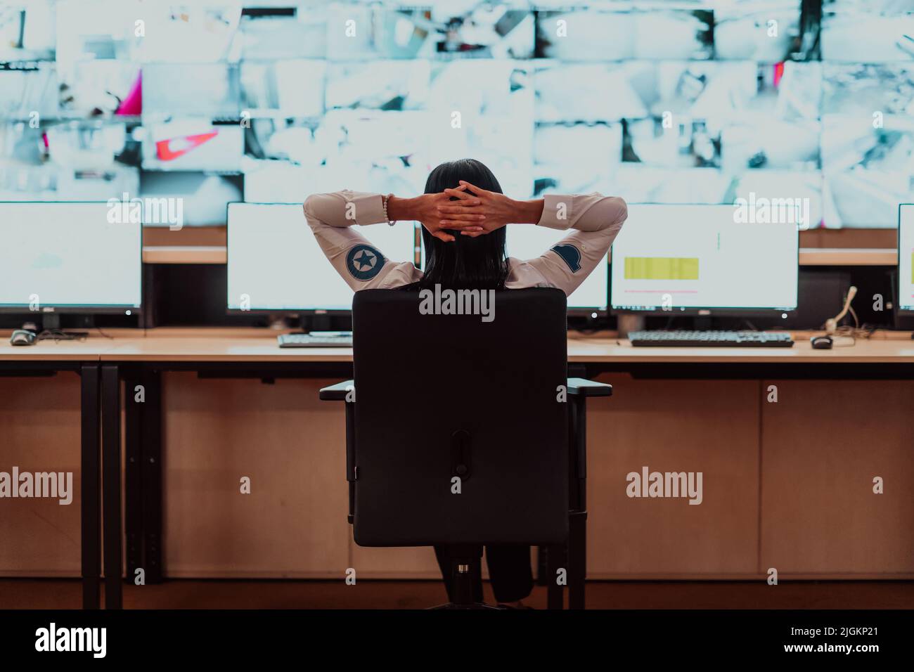 Female security operator working in a data system control room offices ...